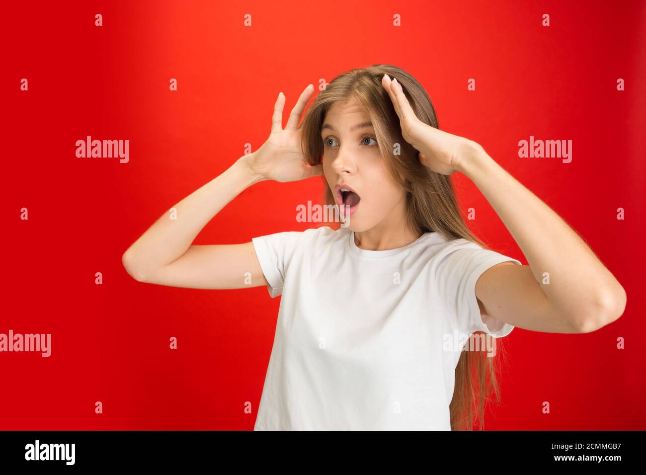 Crazy shocked, wondered. Portrait of young caucasian woman on red ...