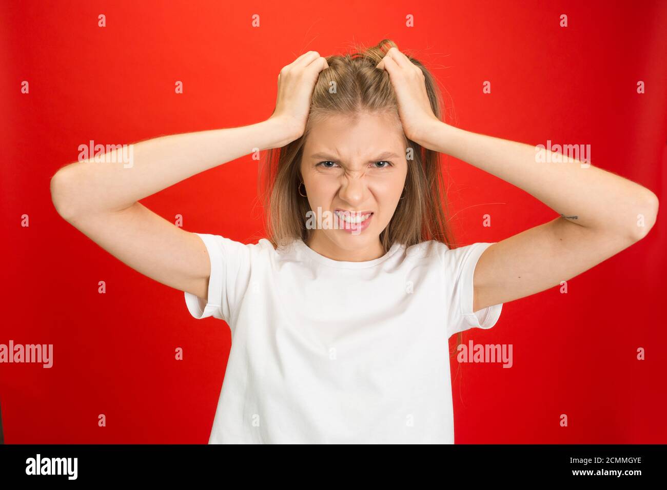 Crazy shocked, wondered. Portrait of young caucasian woman on red ...