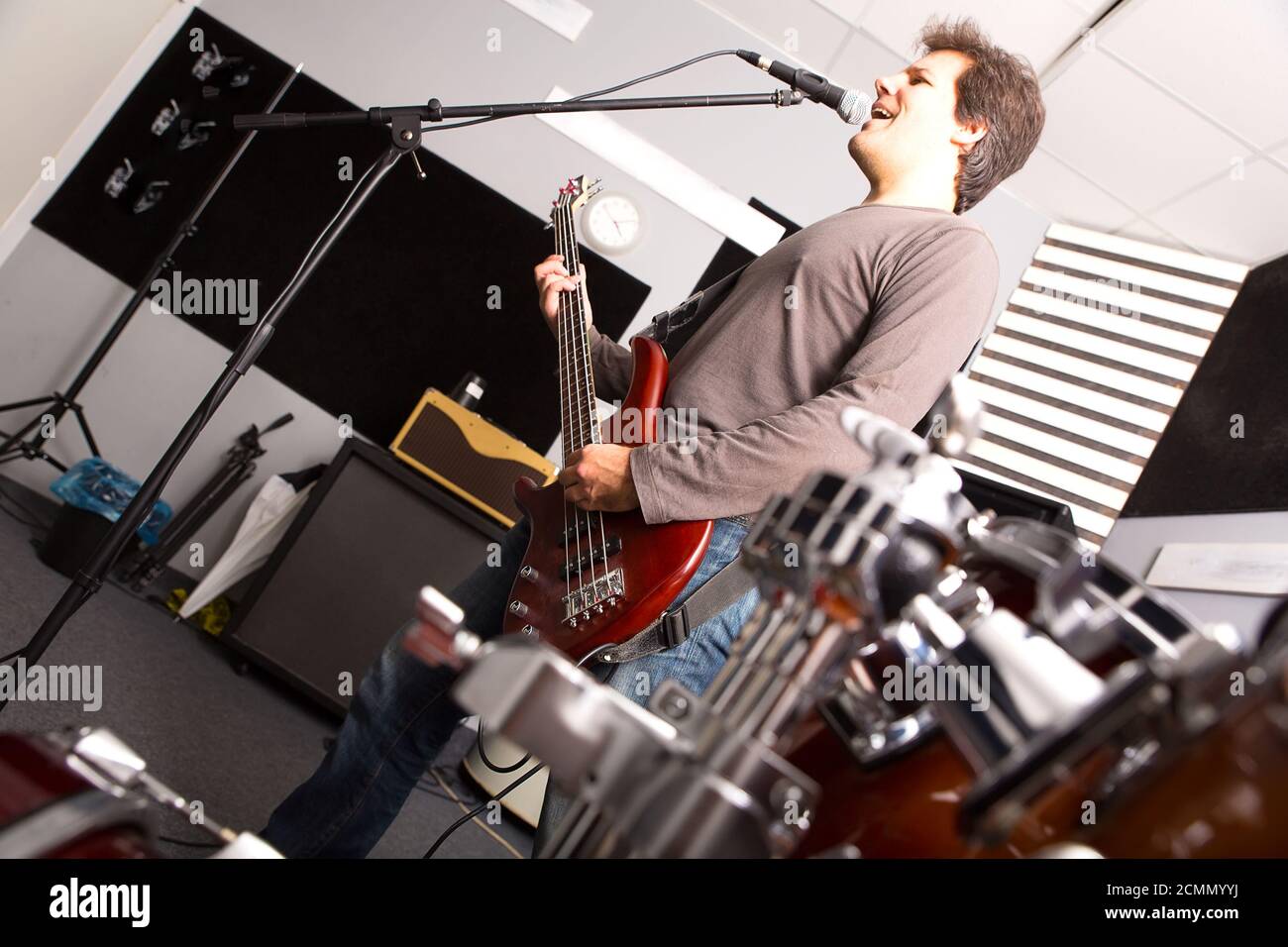 A Rock musician playing passionately bass in the rehearsal Studio Stock ...
