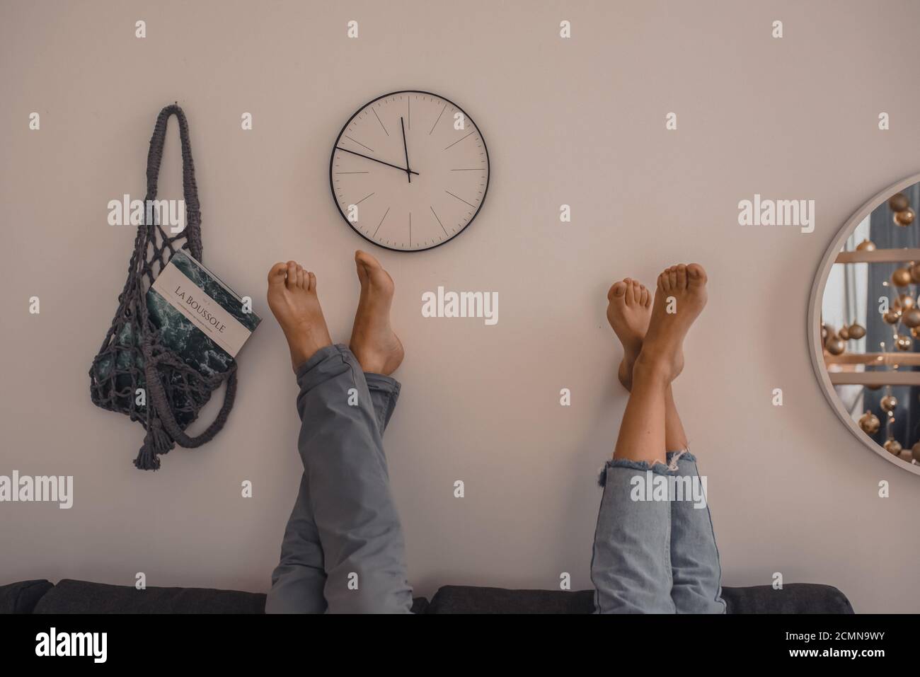 People raised feet up laid on the wall Stock Photo - Alamy