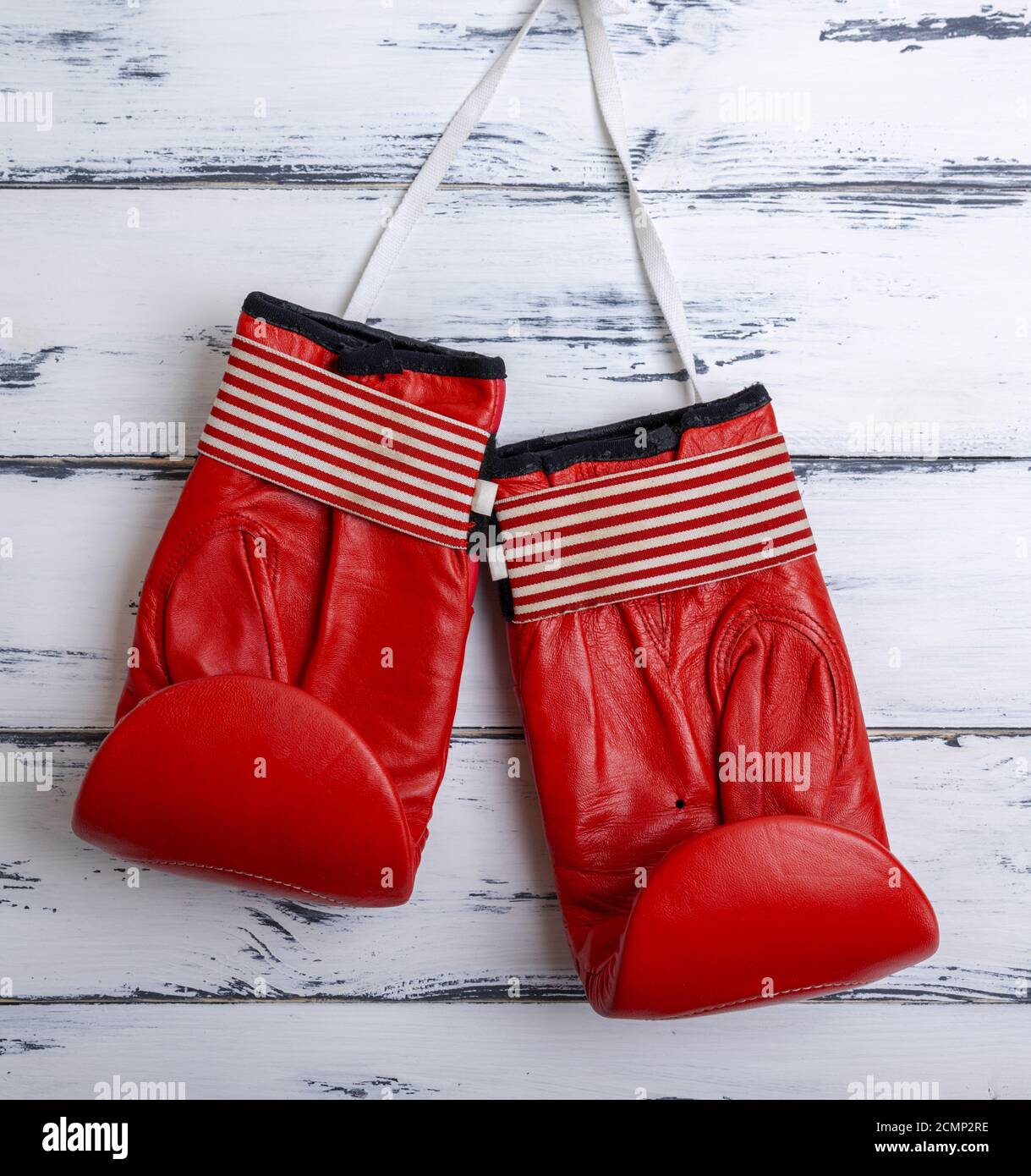 pair of leather worn red boxing gloves hanging on a white lace Stock ...