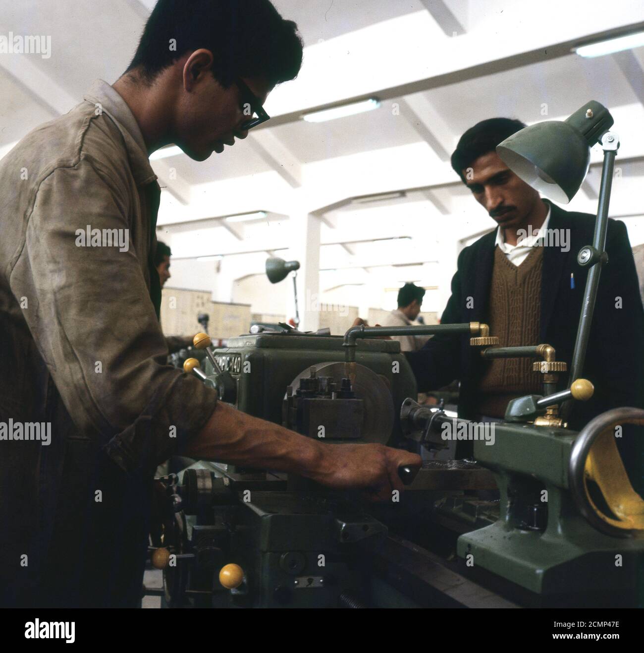 1960s, historical, a young arab male working on an industrial lathe ...