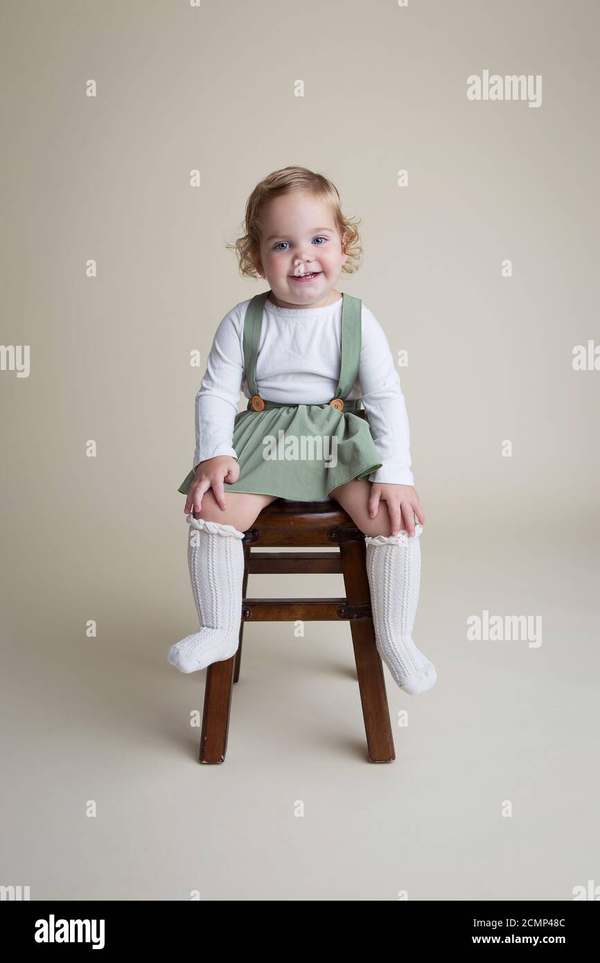 Toddler girl sits on stool Stock Photo - Alamy