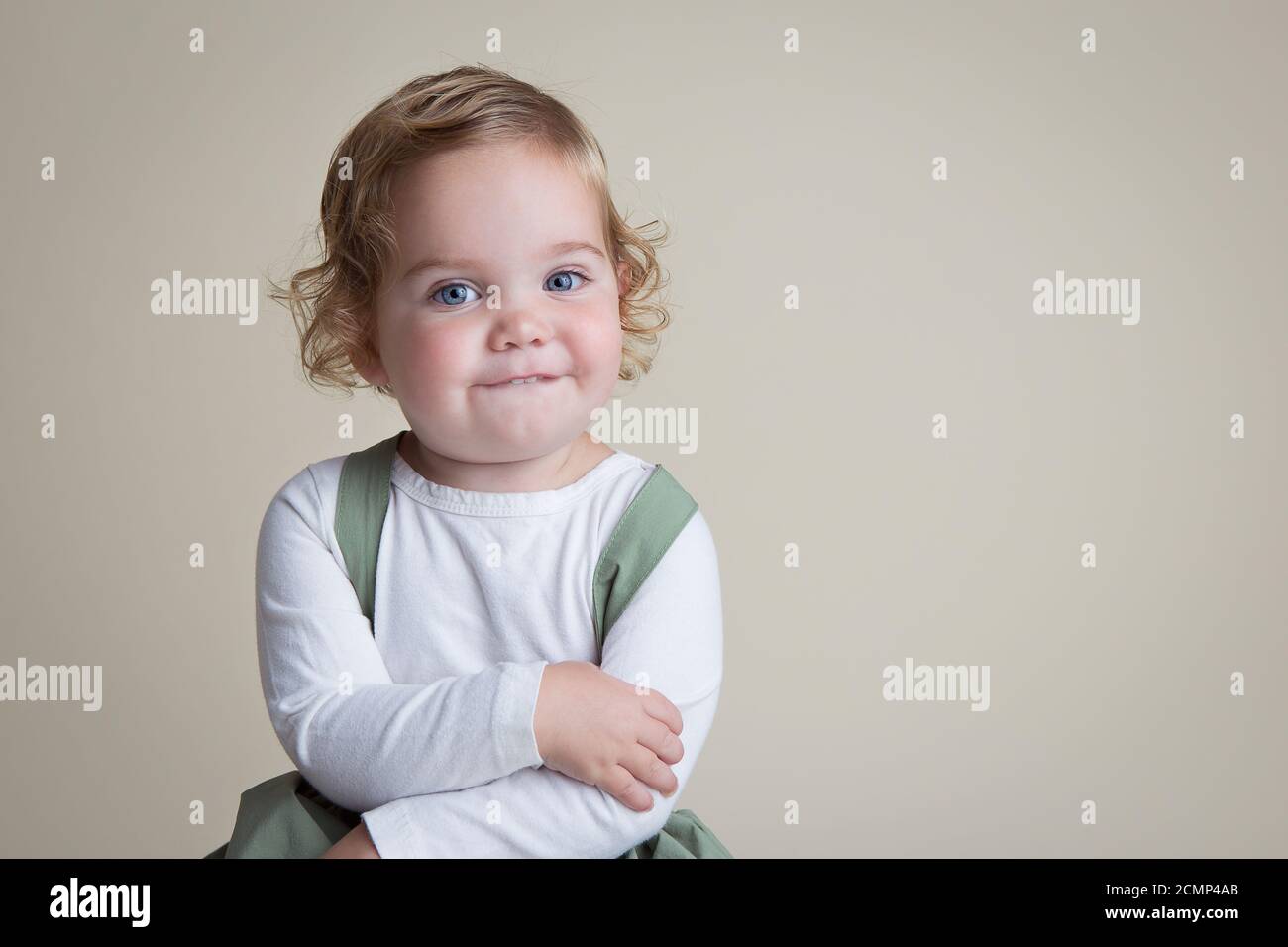 Toddler smiles while crossing arms Stock Photo - Alamy
