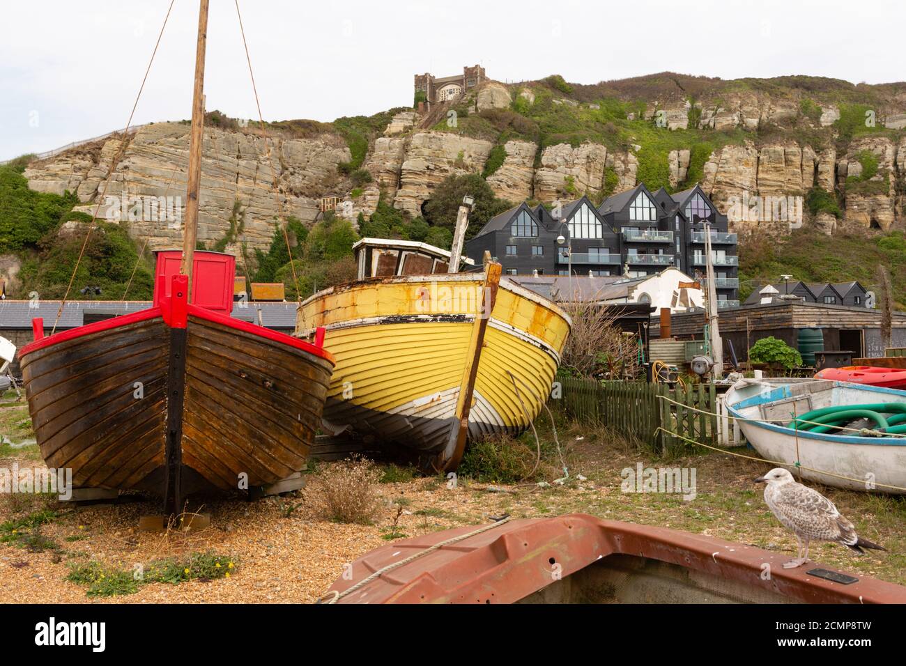 Fishing boats on Hastings beach with a view toward The East Hill lift ...