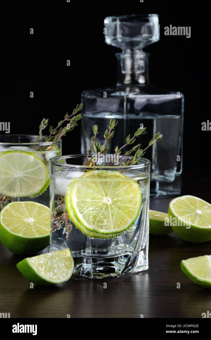 Cocktail with white rum and tonic, a slice of lime and thyme Stock ...