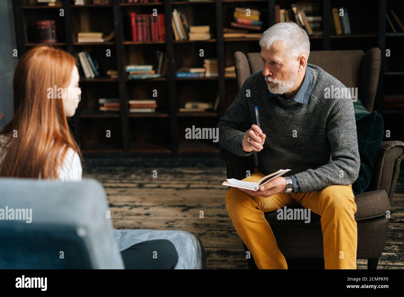 Professional mature man psychologist consulting female patient at ...