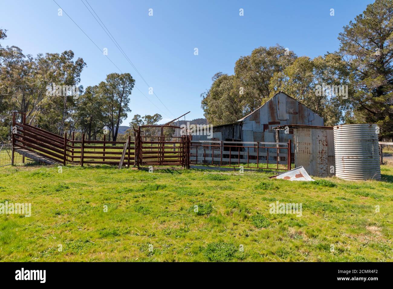 An old rusty shed and tanks in a green field in regional Australia ...