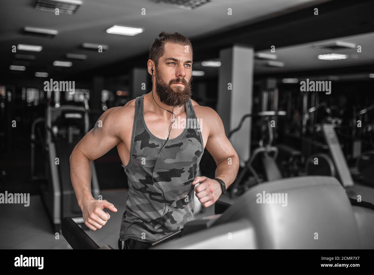 Adult strong bearded man running on treadmill in gym Stock Photo - Alamy