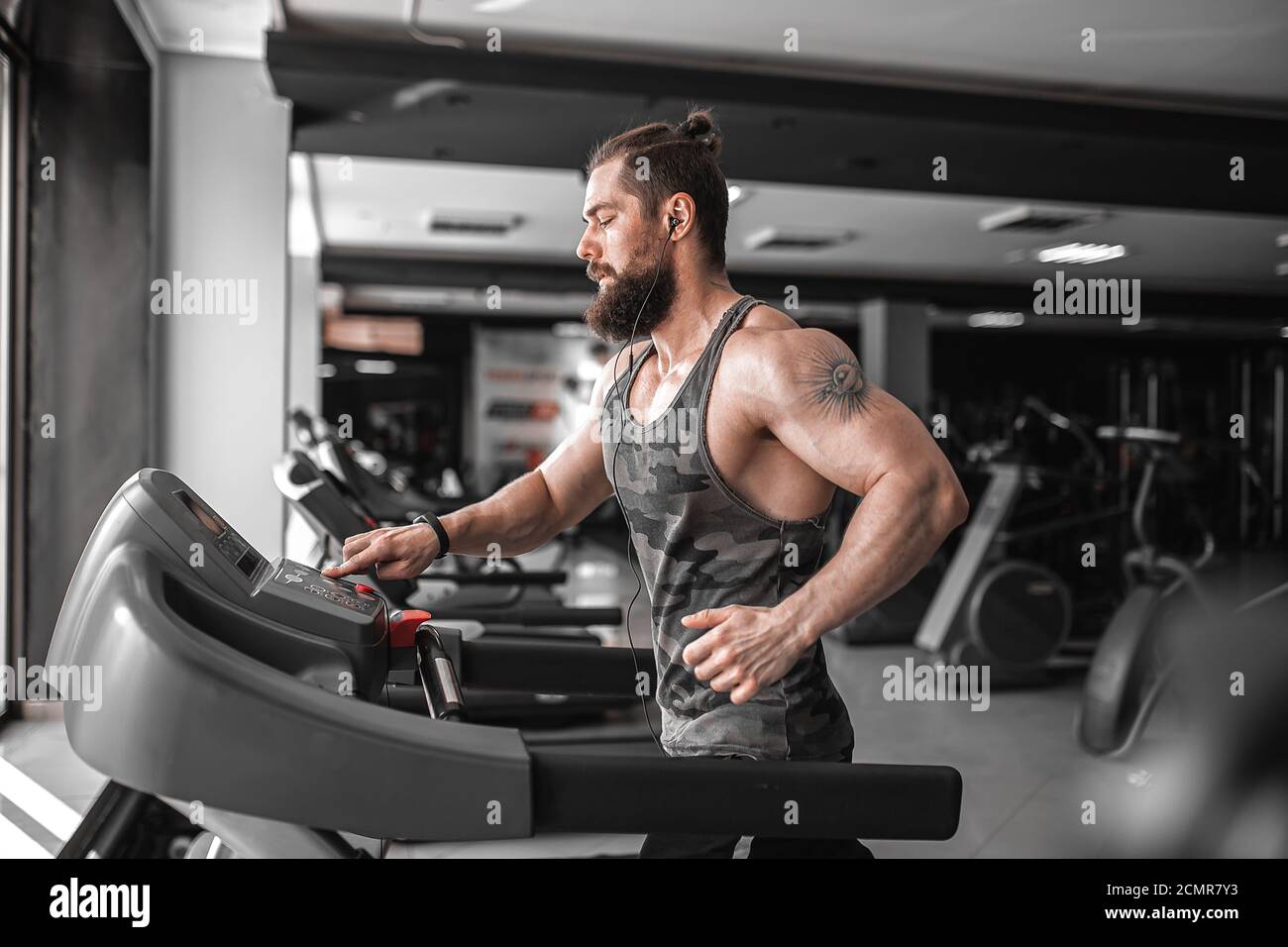 Adult strong bearded man running on treadmill in gym Stock Photo - Alamy
