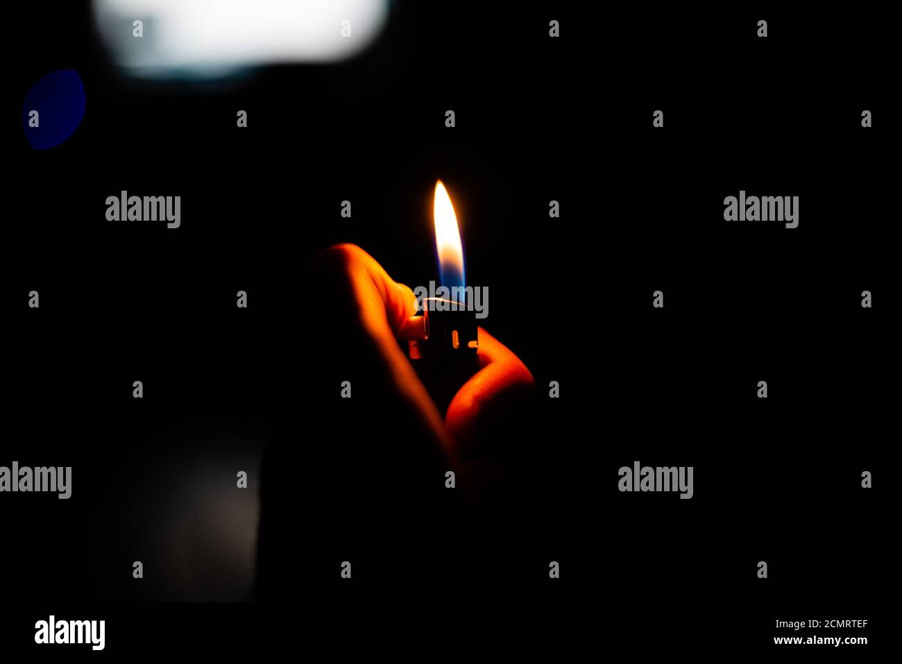Abstract shot of a person holding a lit lighter in a dark room Stock ...