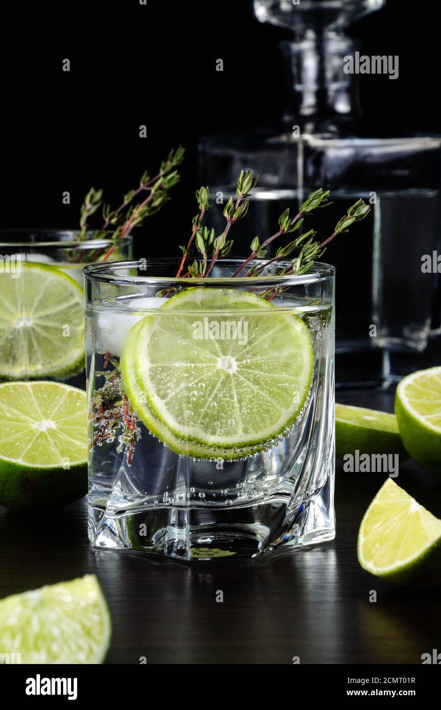 Cocktail with white rum and tonic, a slice of lime and thyme Stock ...