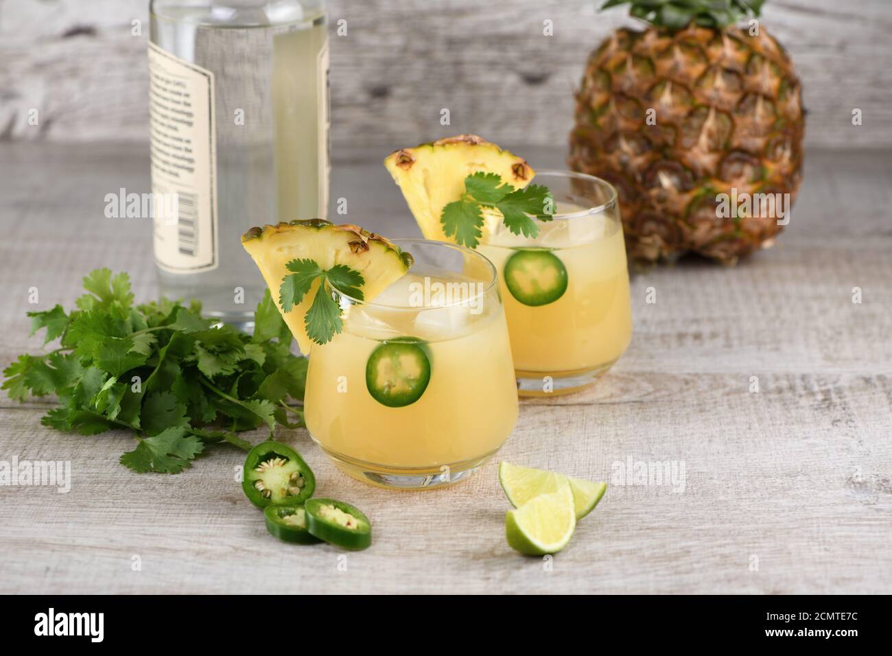 Tequila cocktail with pineapple juice, jalapeno slices and cilantro ...