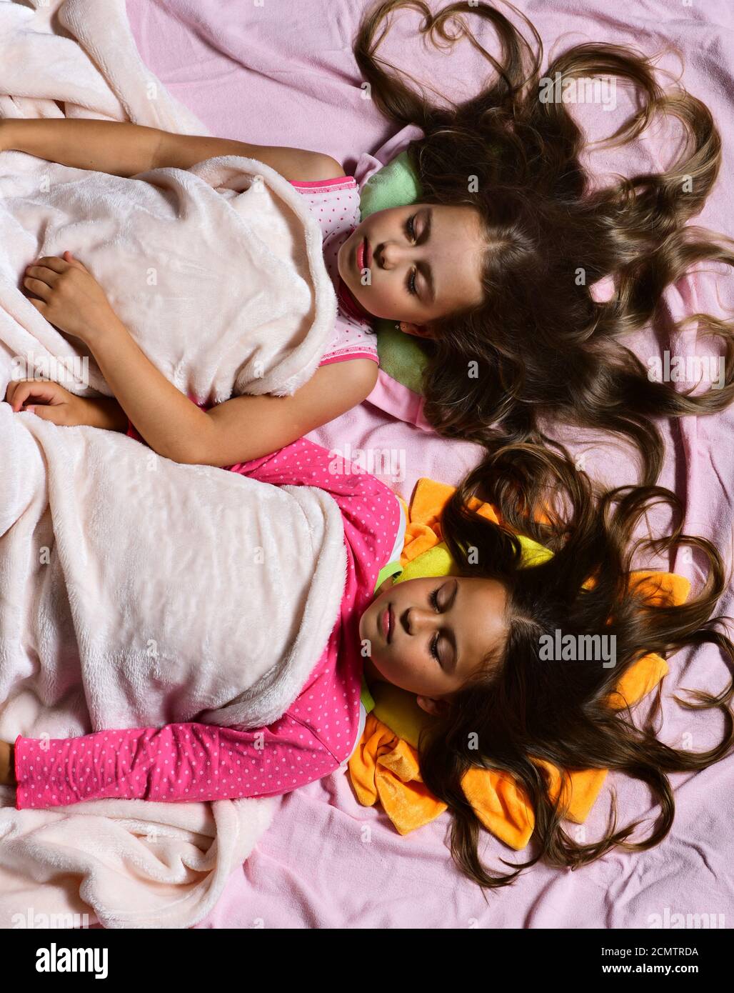 Girls on white and pink bed sheets background. Kids with sleepy faces ...