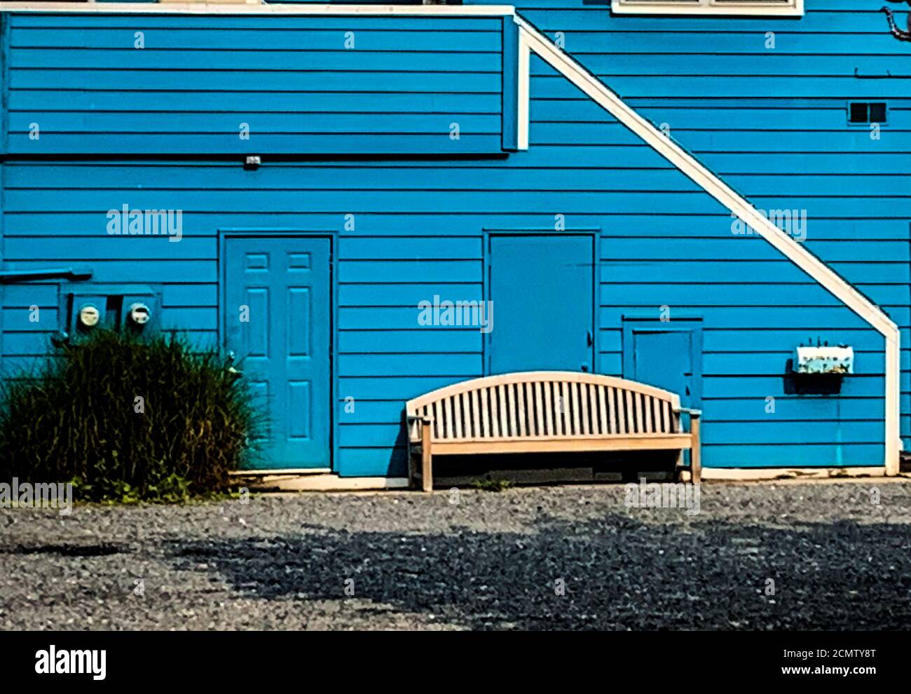 Outdoor bench against the side of a blue house Stock Photo - Alamy