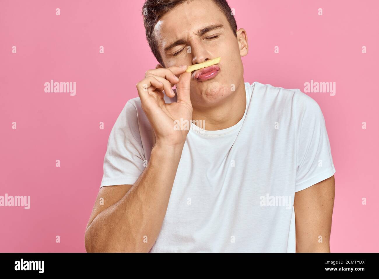 Cute man with fries in hands emotions model fast food pink background ...