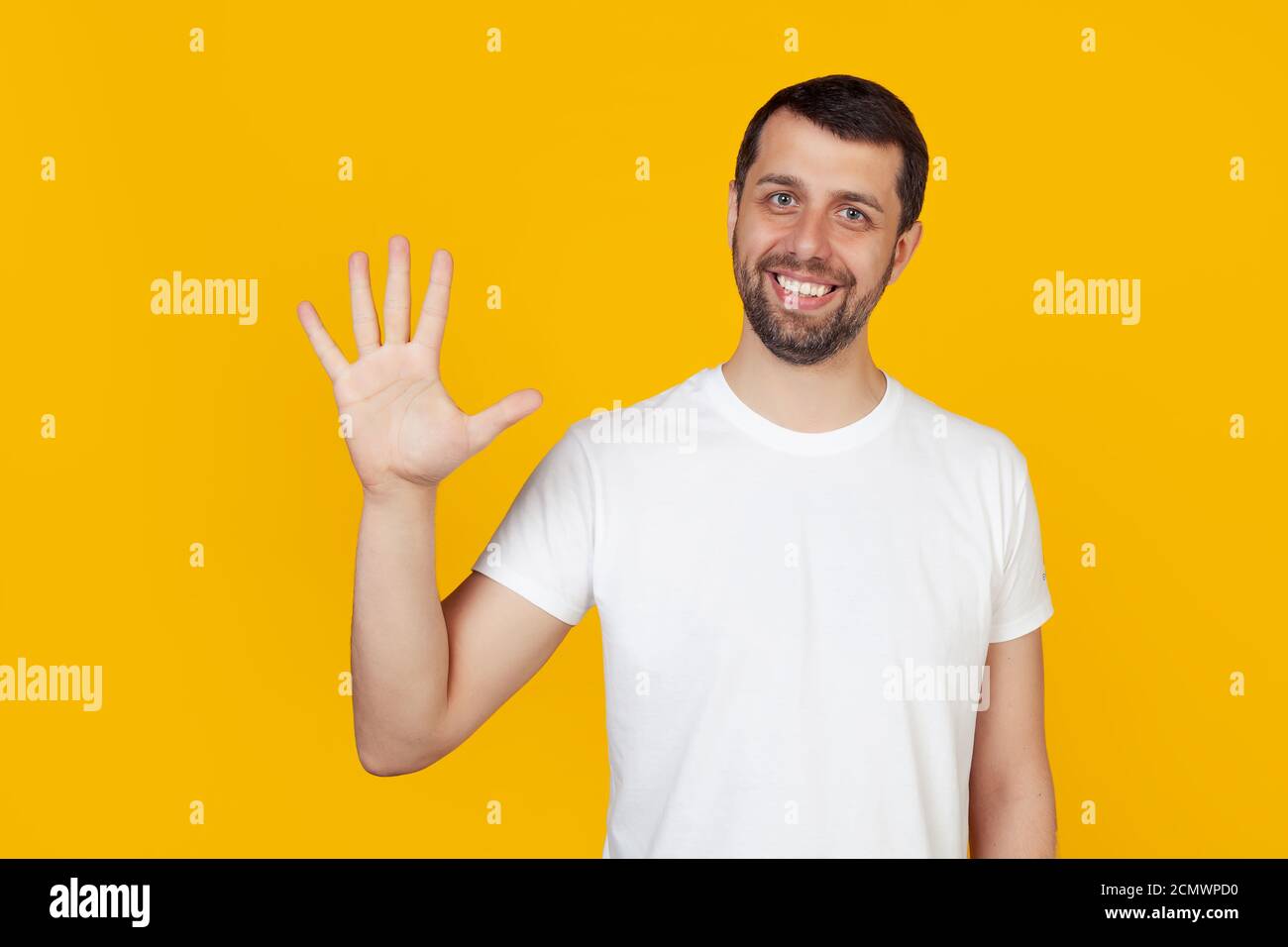 Modern young man with a beard in a white tank top shows number five ...