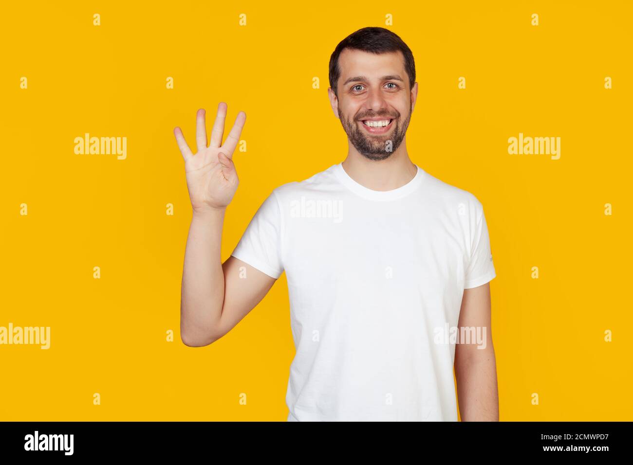 Modern young man with a beard in a white tank top shows number four ...
