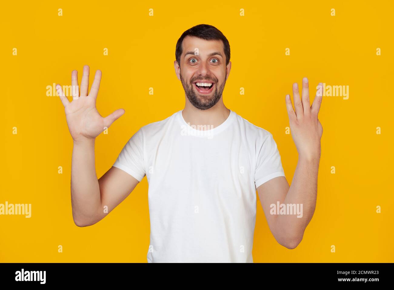 Modern young man with a beard in a white tank top shows number nine ...