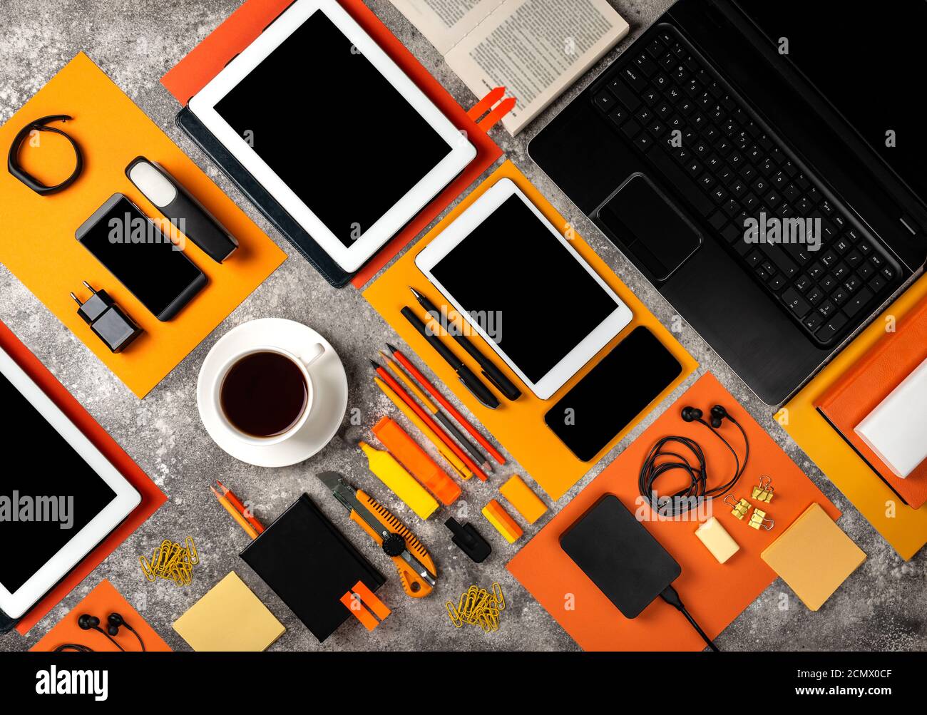 Workplace with orange office tools and gadgets on the desk background ...