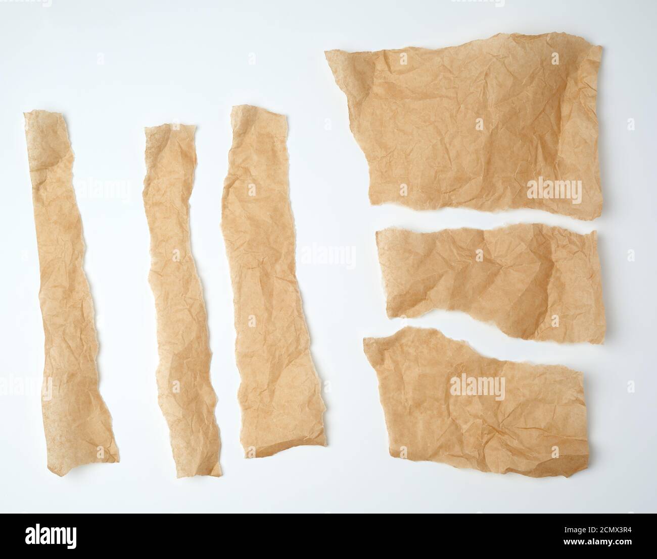 torn brown pieces of parchment paper on a white background Stock Photo ...