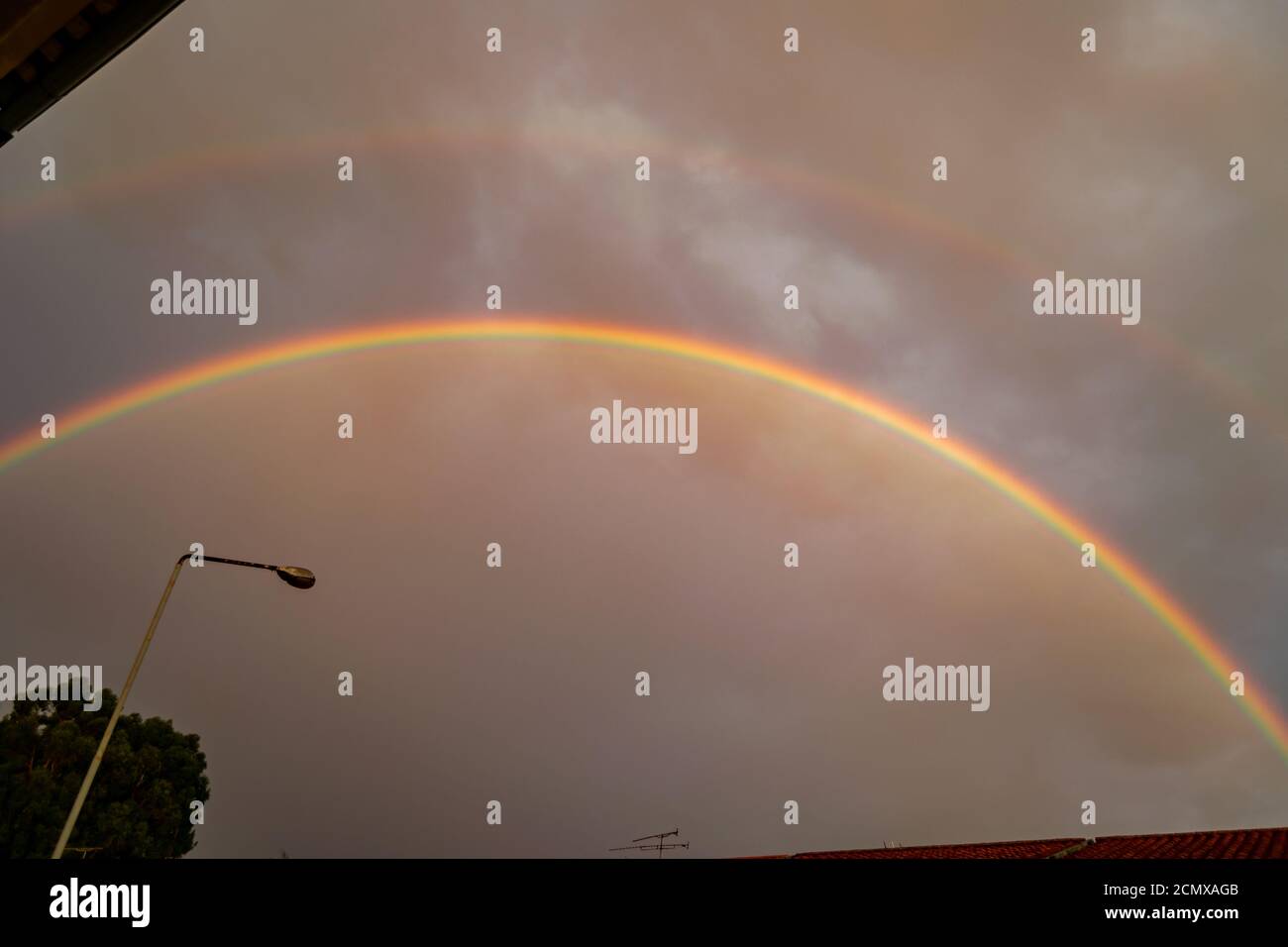 Rainbow in darkness, heavy cloudy sky with rainbow Stock Photo - Alamy