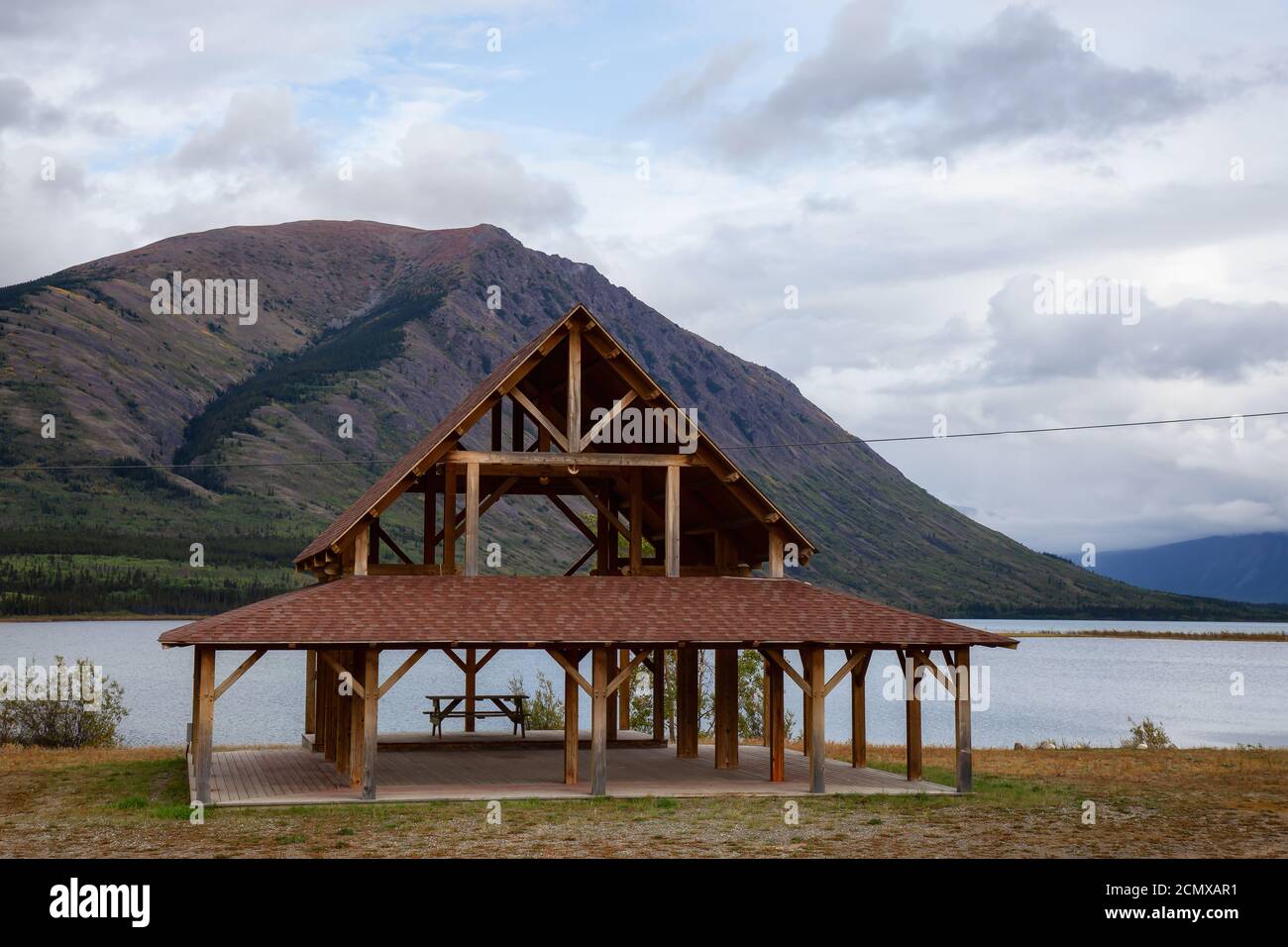 Outdoor public hall in front of a lake with mountains in the background ...