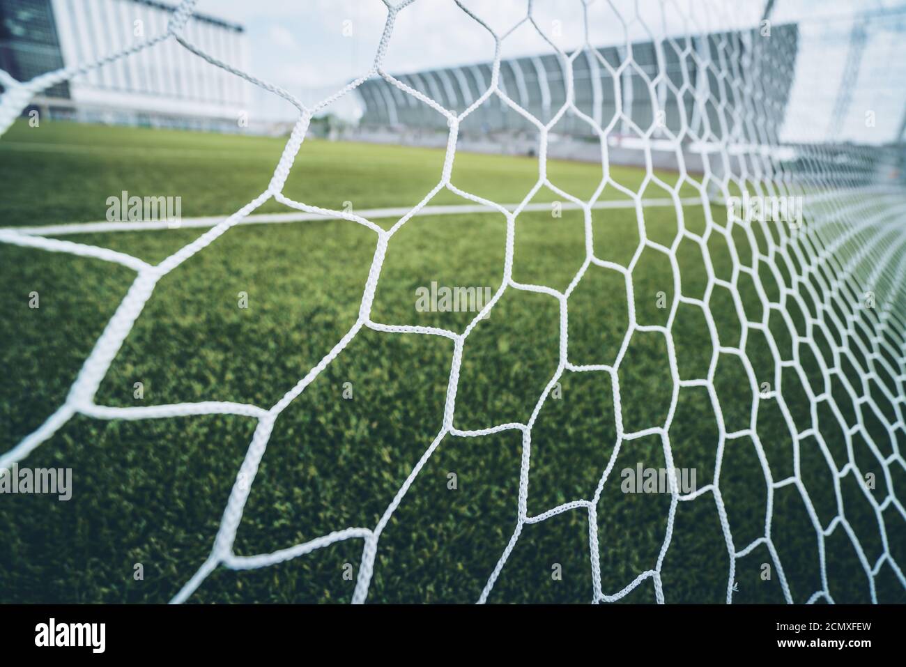 Soccer football net background over green grass and blurry stadium ...