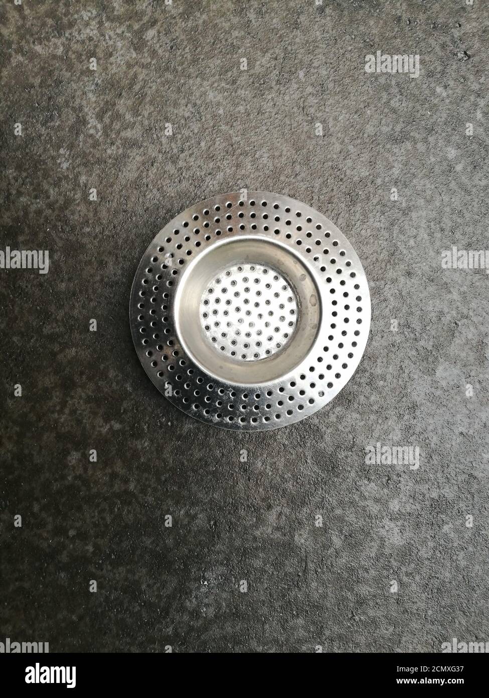 Top view of a stainless steel sink strainer on a gray background Stock ...