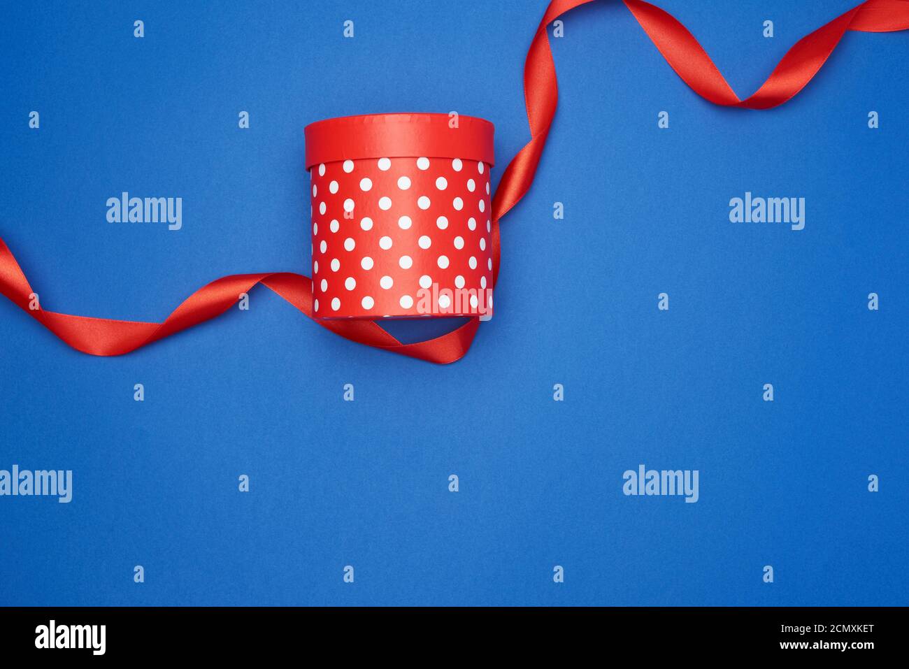 closed cardboard red box with white polka dots and red silk ribbon ...