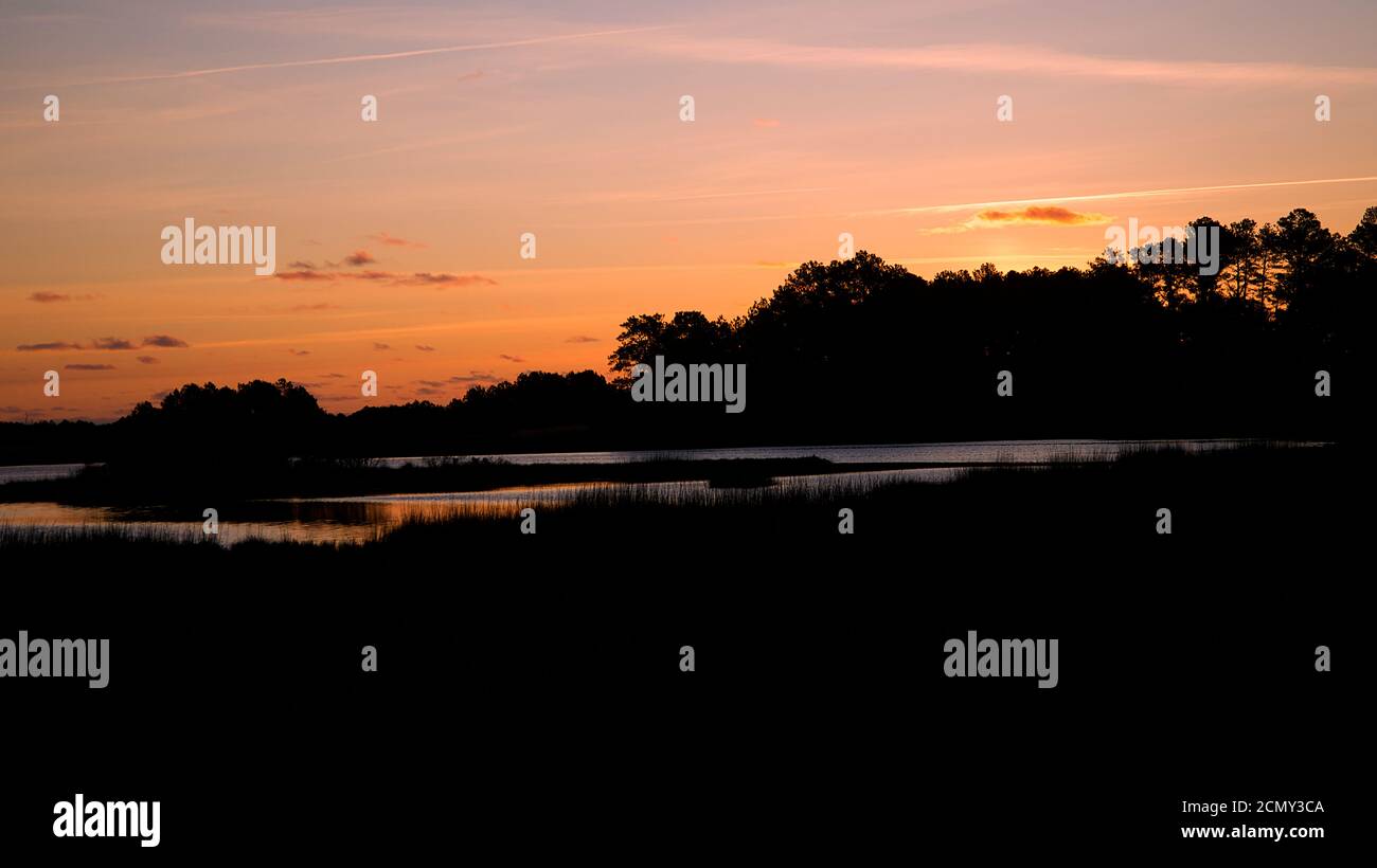 Sunset over Assateague Island over marshes, salt water bay with ...