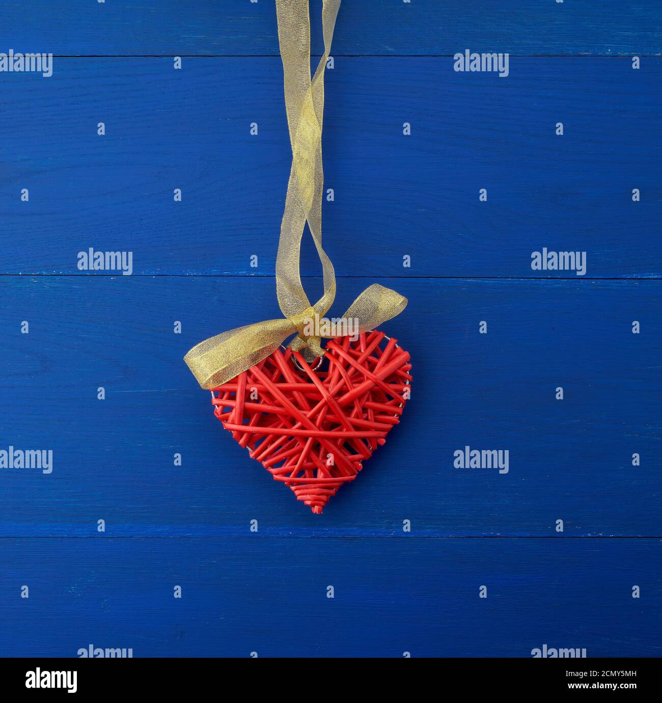 red wicker decorative heart hanging on silk golden ribbon Stock Photo ...