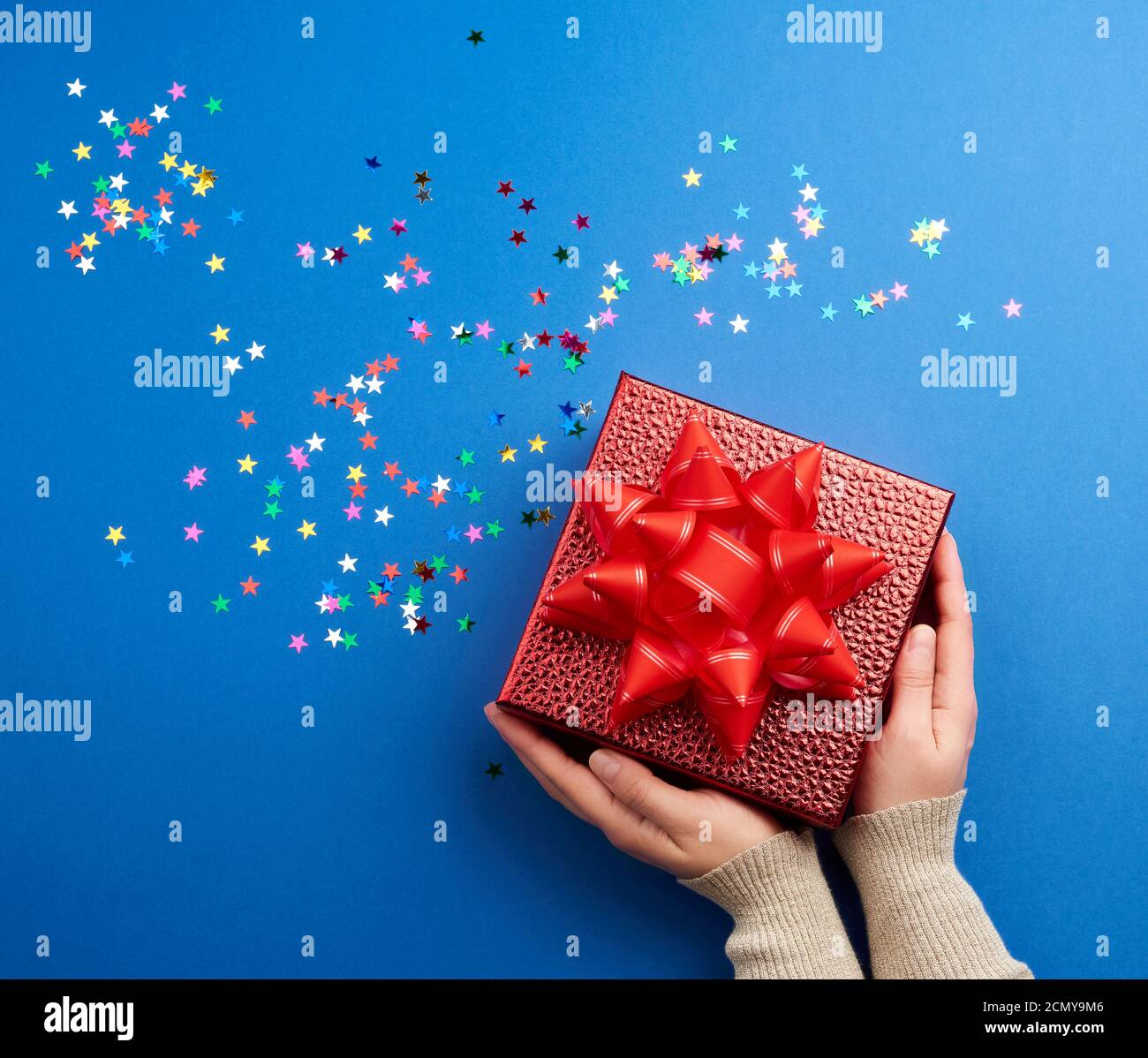 female hands holds a beautiful shiny red box with a big red bow Stock ...