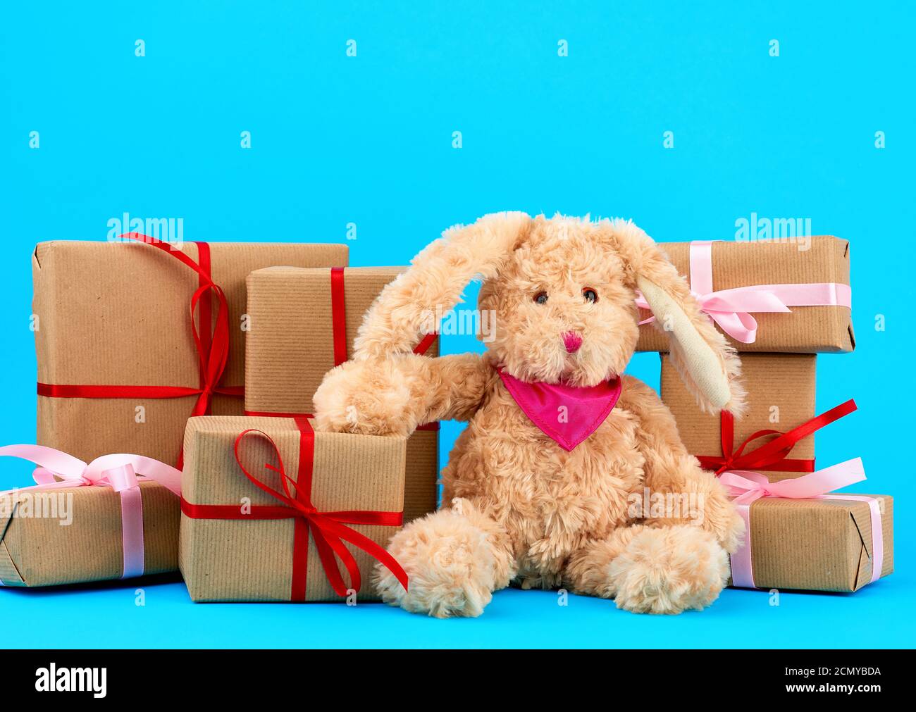 cute little brown plush rabbit and a stack of boxes wrapped in brown ...