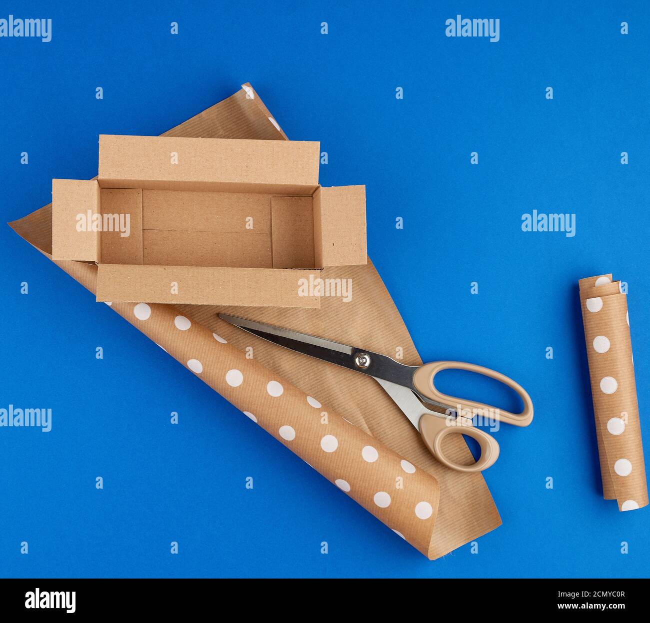 empty cardboard brown box, roll of wrapping paper and scissors Stock ...