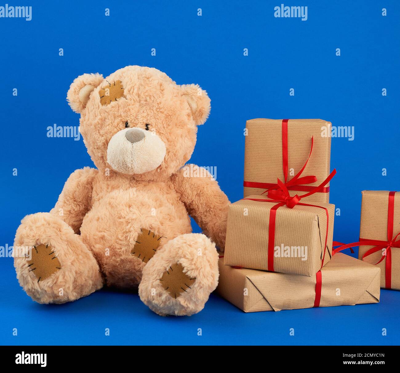 big beige teddy bear with patches Stock Photo - Alamy