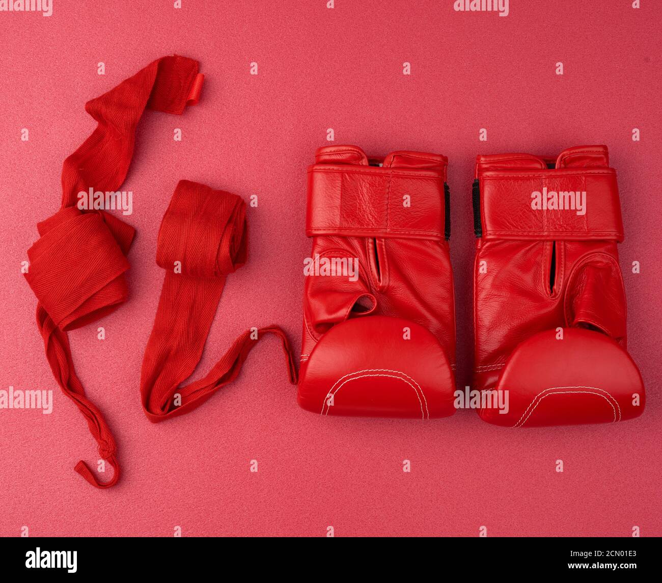 pair of red leather boxing gloves and a textile red elastic bandage for ...