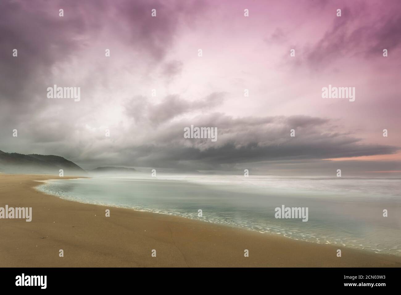 the beach in a dramatic sky and soft waves captured Stock Photo - Alamy