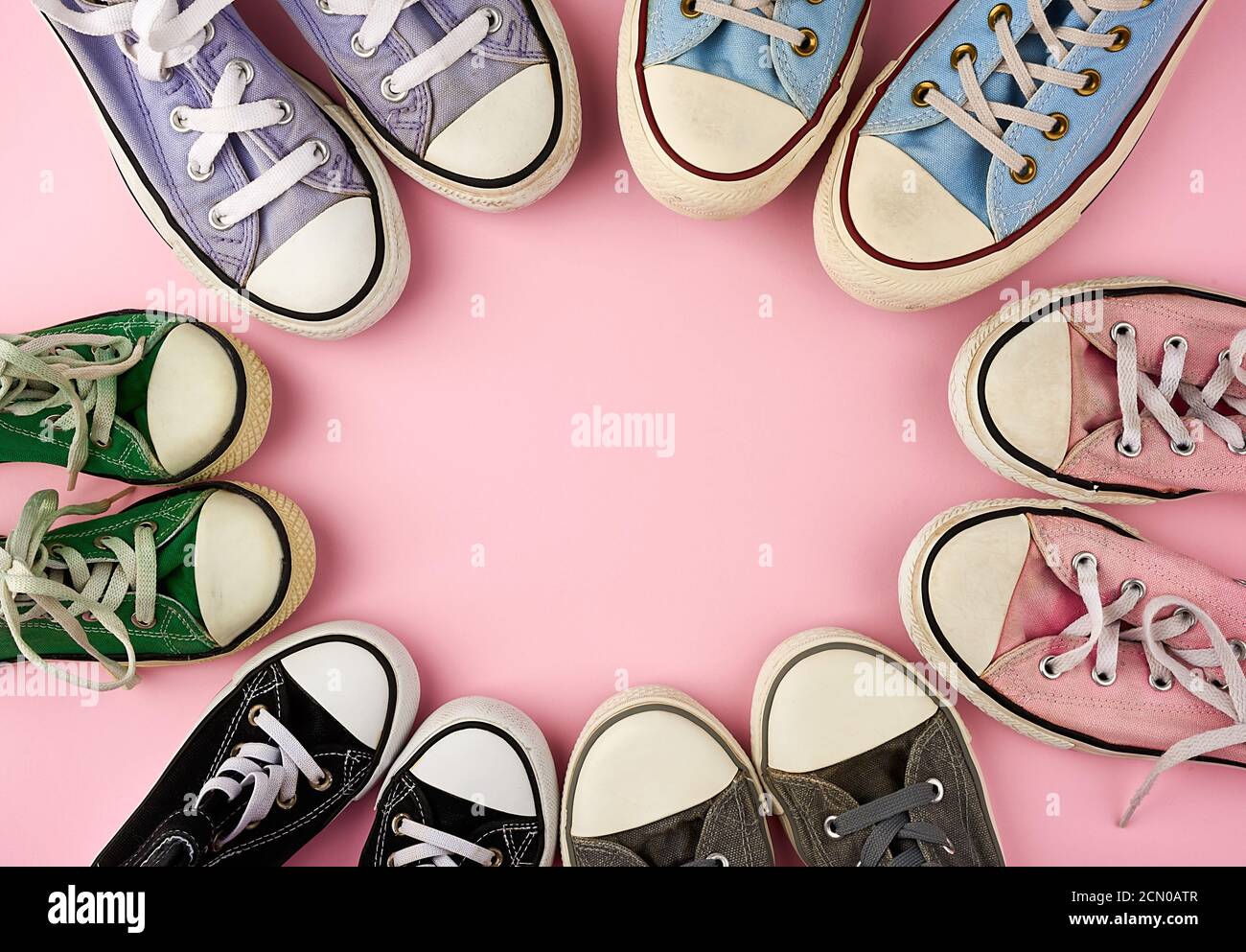 many multi-colored well-worn textile sneakers of different sizes on a ...