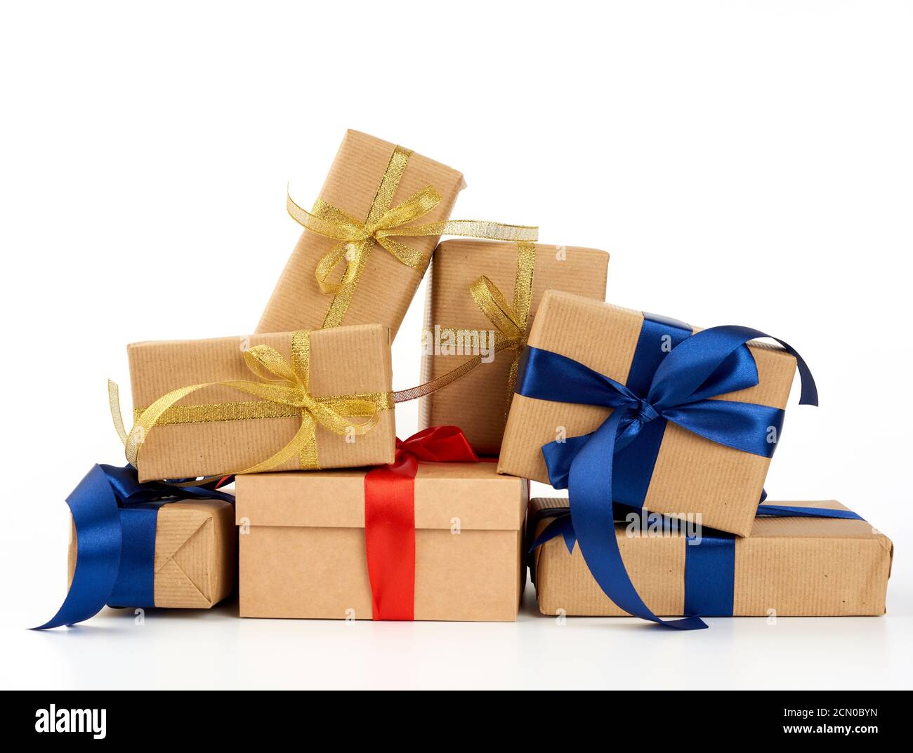 stack of gifts wrapped in brown kraft paper and tied with silk blue and ...