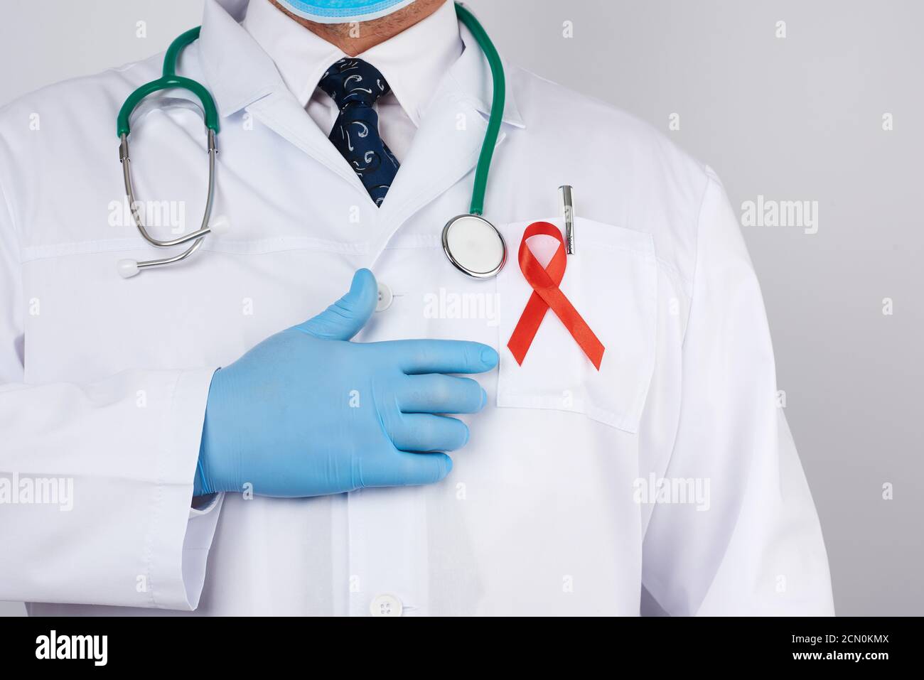 male doctor in a white coat and tie is standing on a white background ...