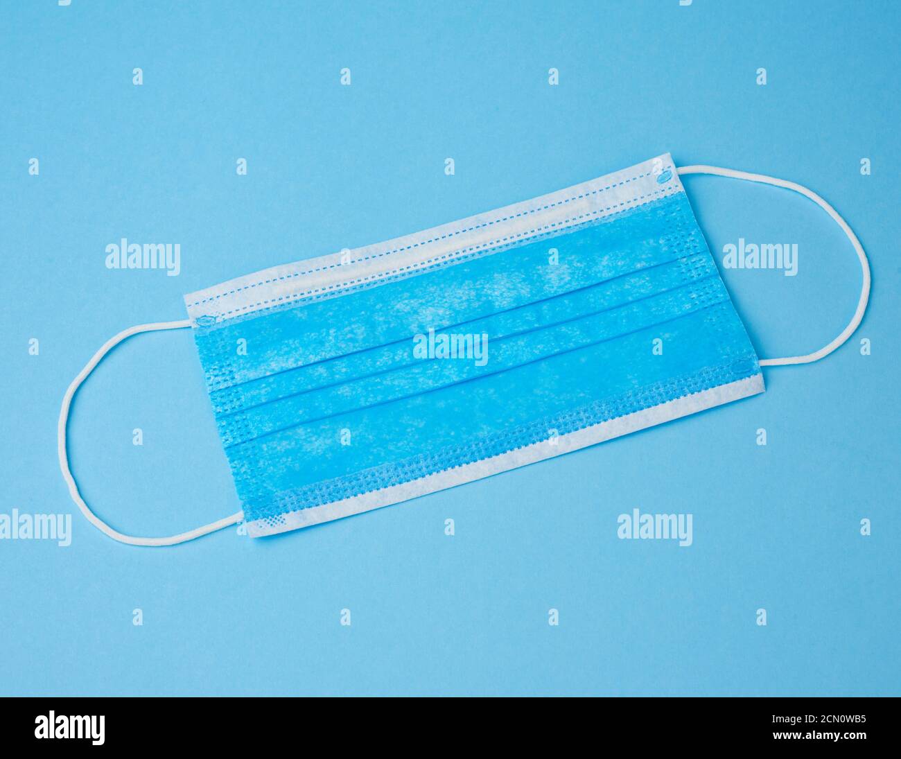 blue textile medical face mask with rubber bands from viruses and ...