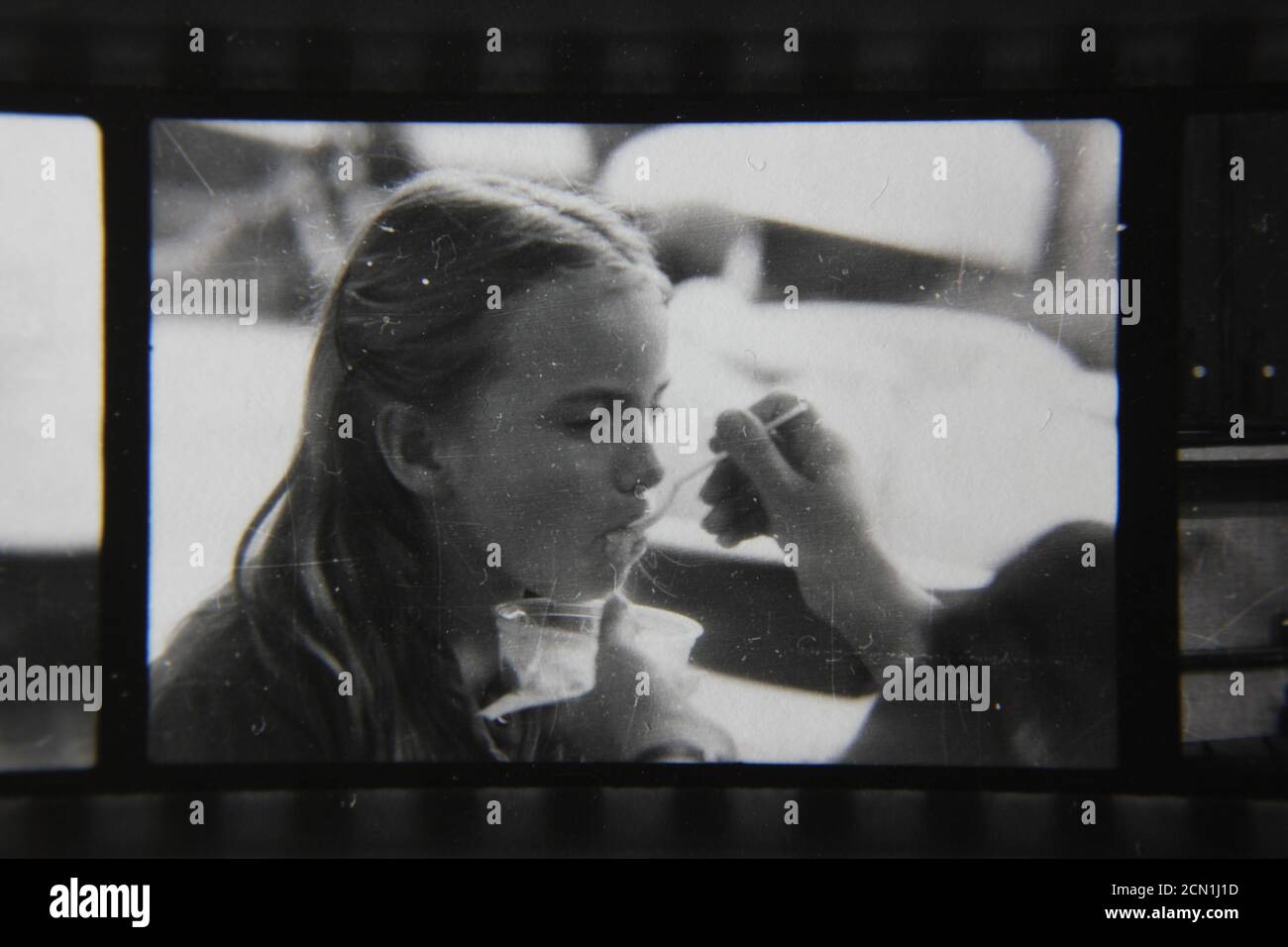 Fine 1970s vintage black and white photography of a young lady sampling ...