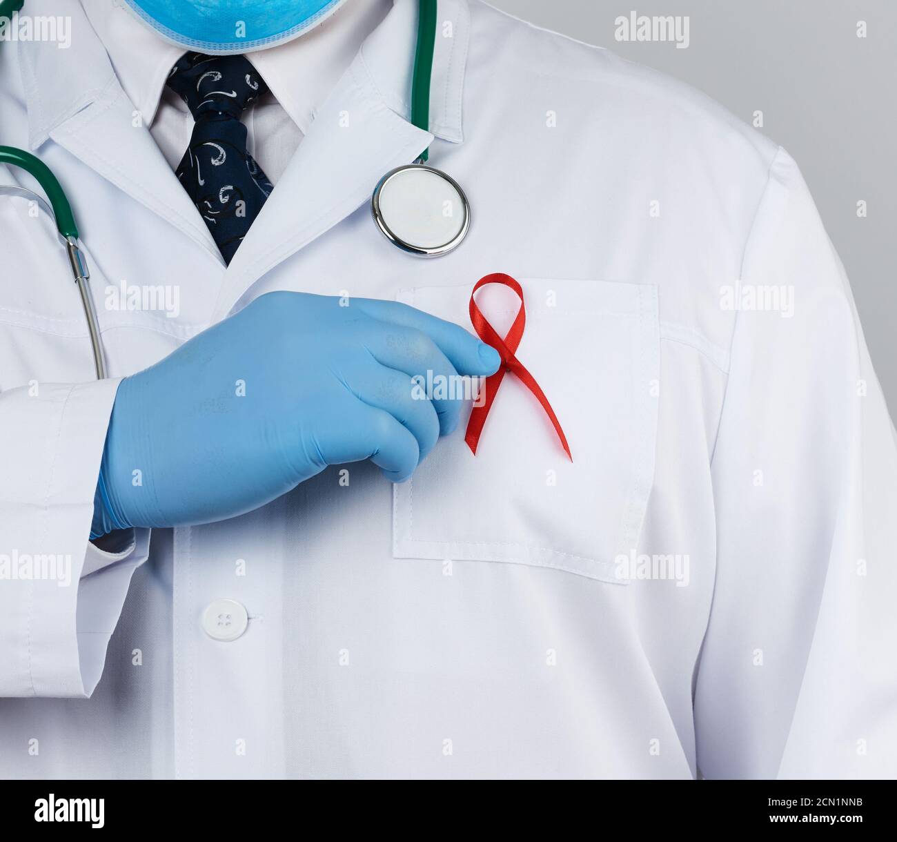 doctor in a white coat and tie is standing on a white background, red ...