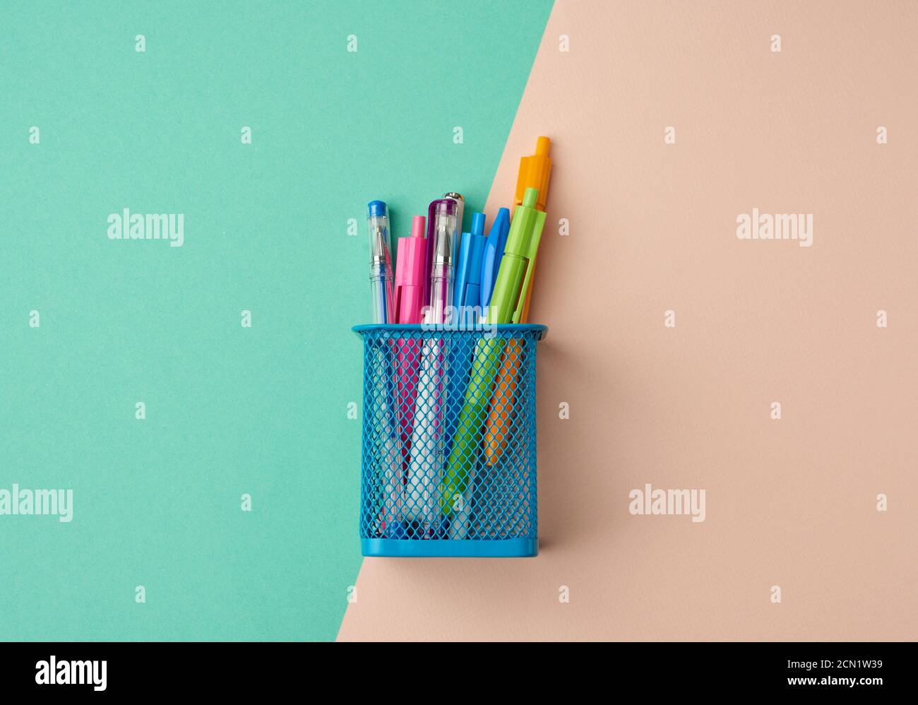 blue metal container for stationery, inside multi-colored plastic pens ...