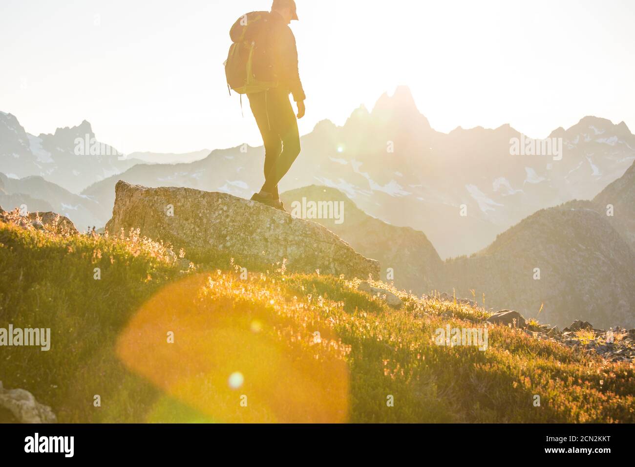 Side view of hiker backpacking across a high mountain range Stock Photo ...