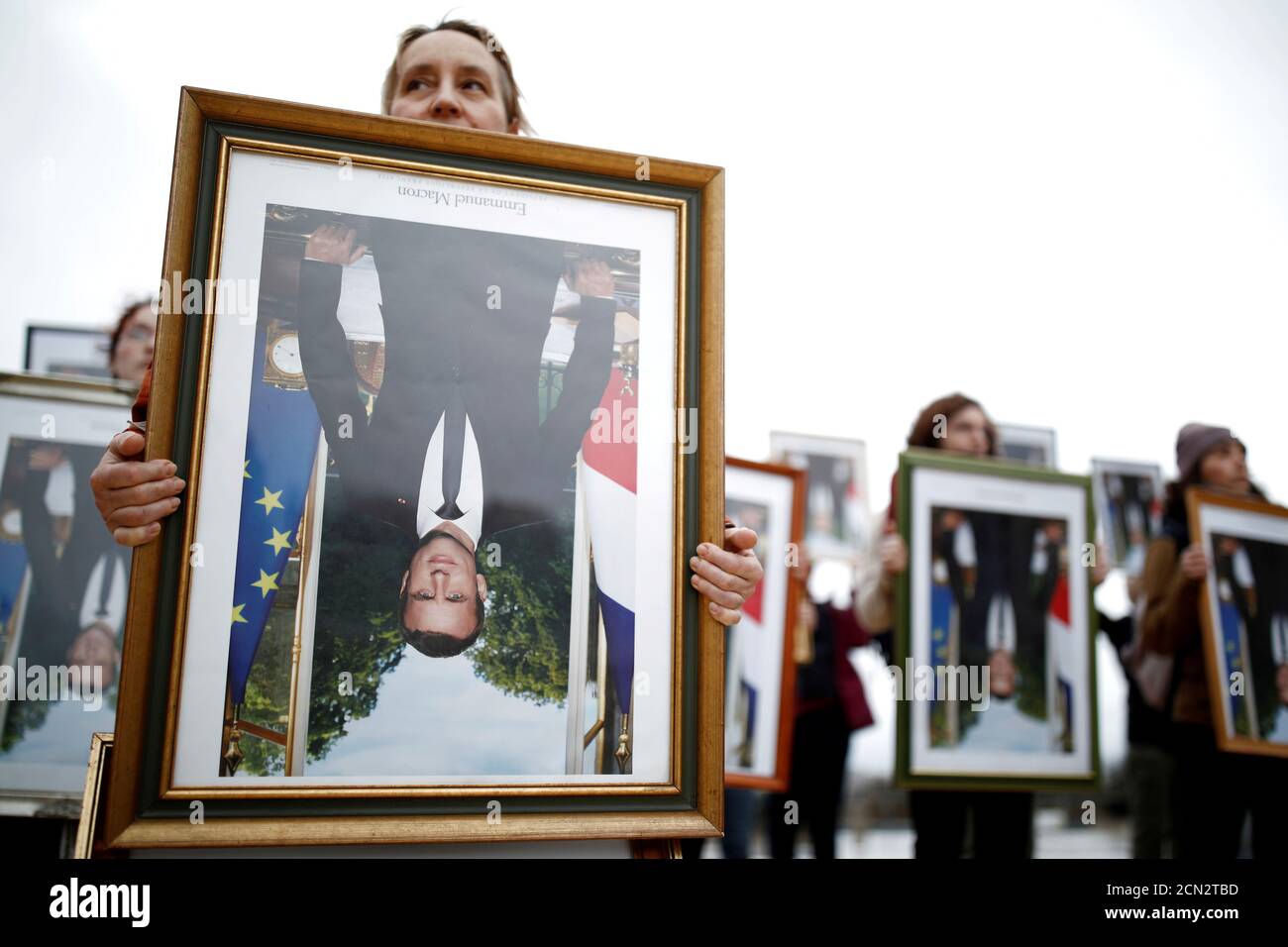 French climate activists hold inverted portraits of French President ...
