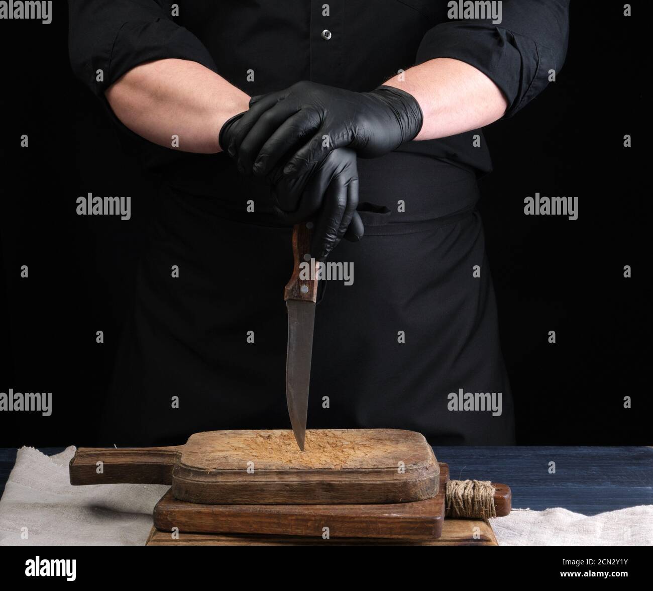 chef in a black shirt and black latex gloves holds a vintage kitchen ...