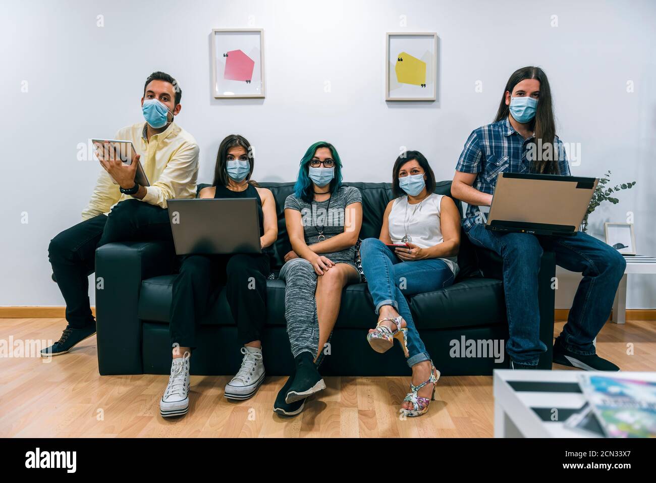 Group of young people wearing masks during a break in a Coworking ...