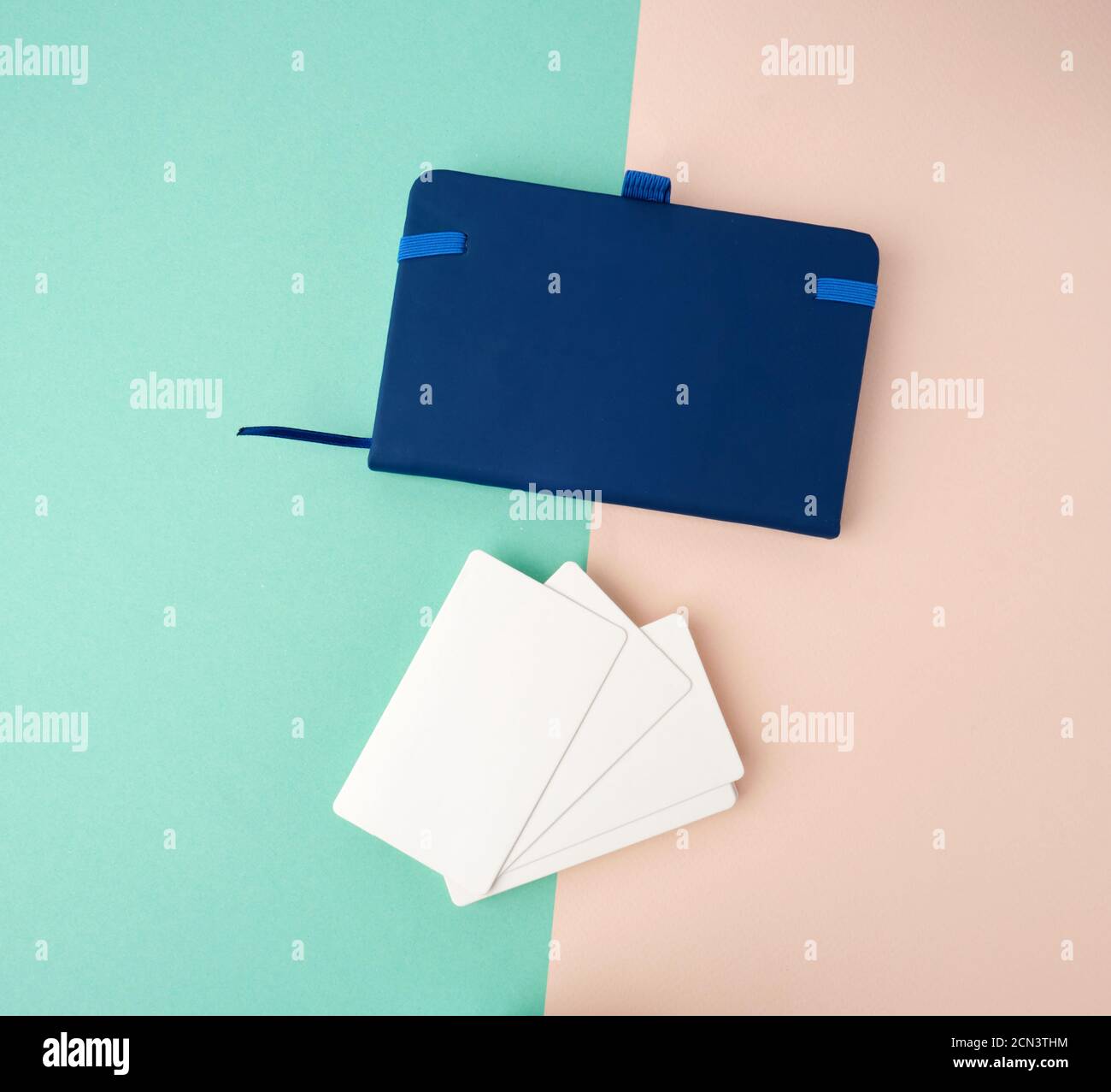 stack of rectangular white blank business cards and blue notebook on a ...